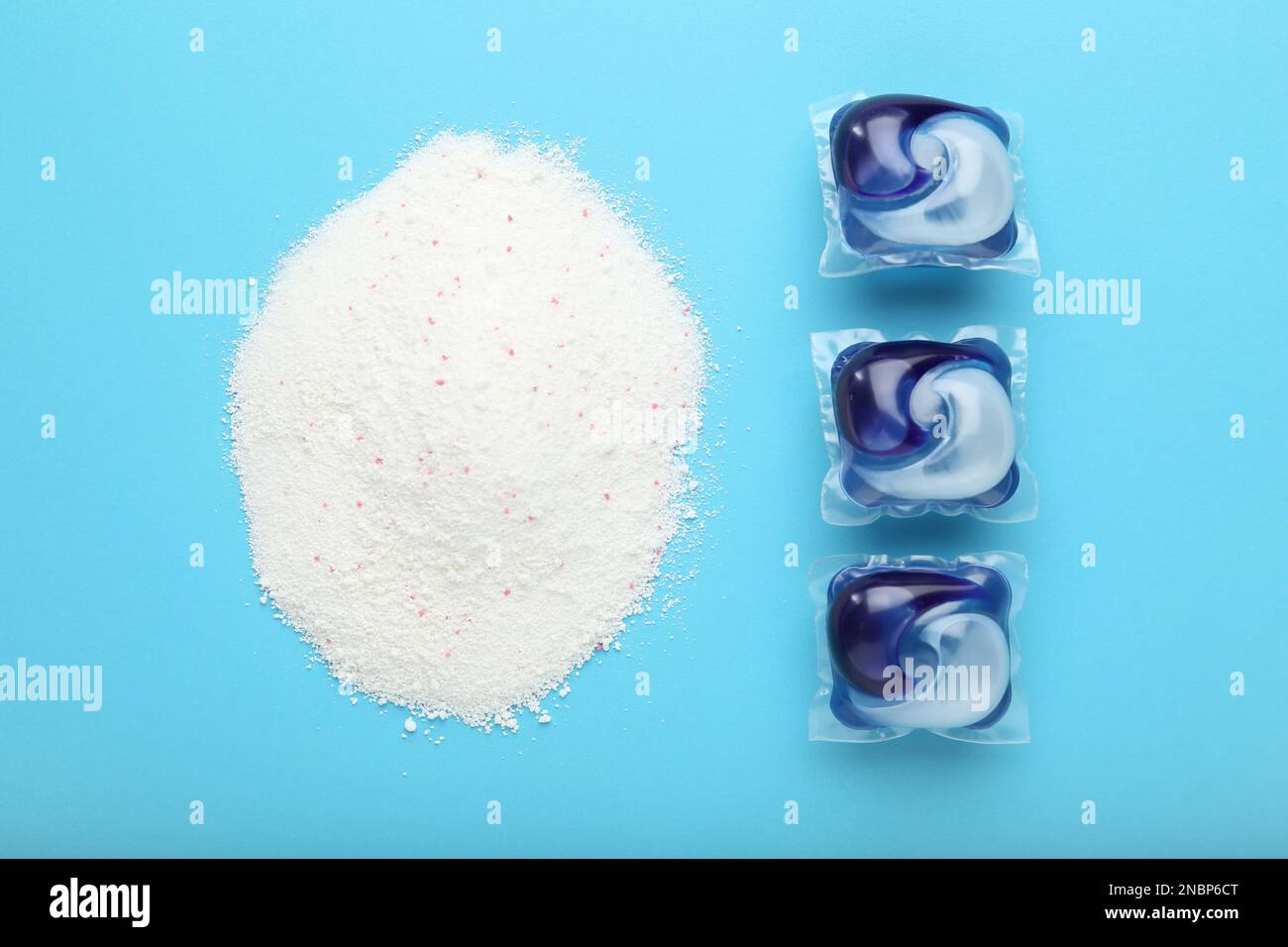 Laundry capsules and washing powder on turquoise background, flat lay ...