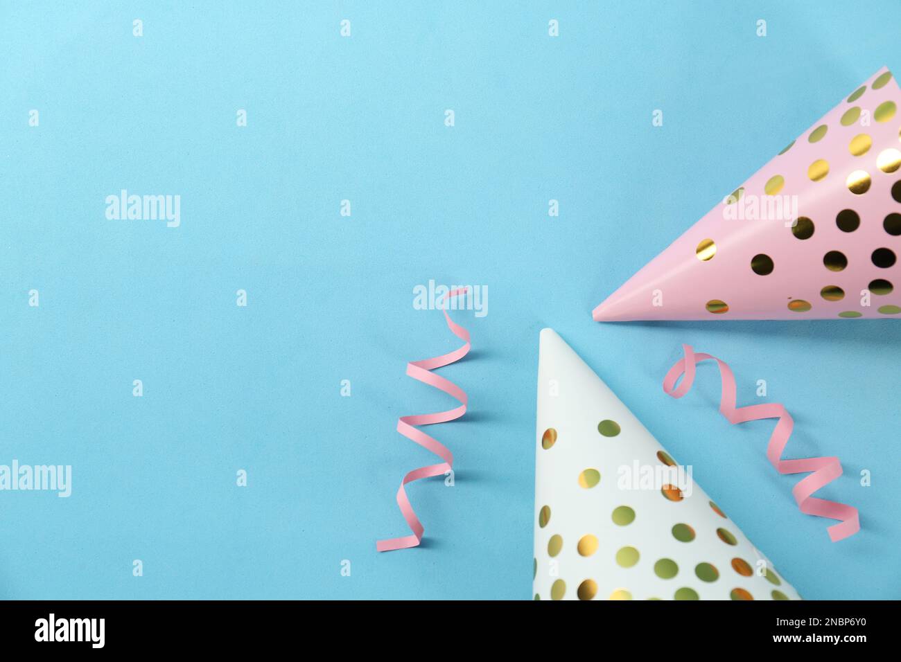 Bright party hats and serpentine streamers on light blue background ...