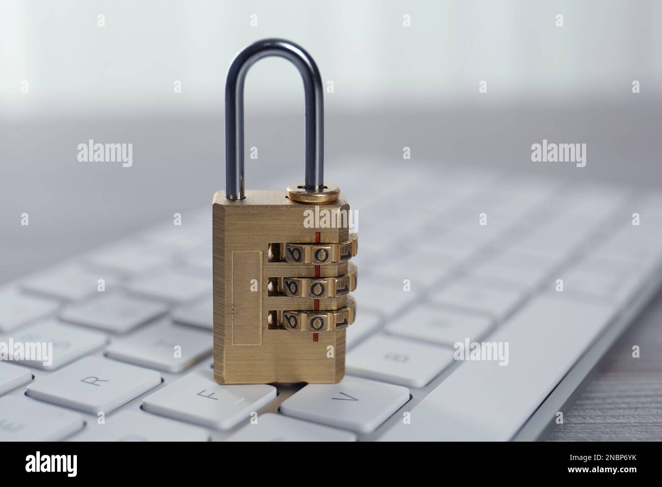 Metal code padlock and computer keyboard on table, closeup. Cyber ...