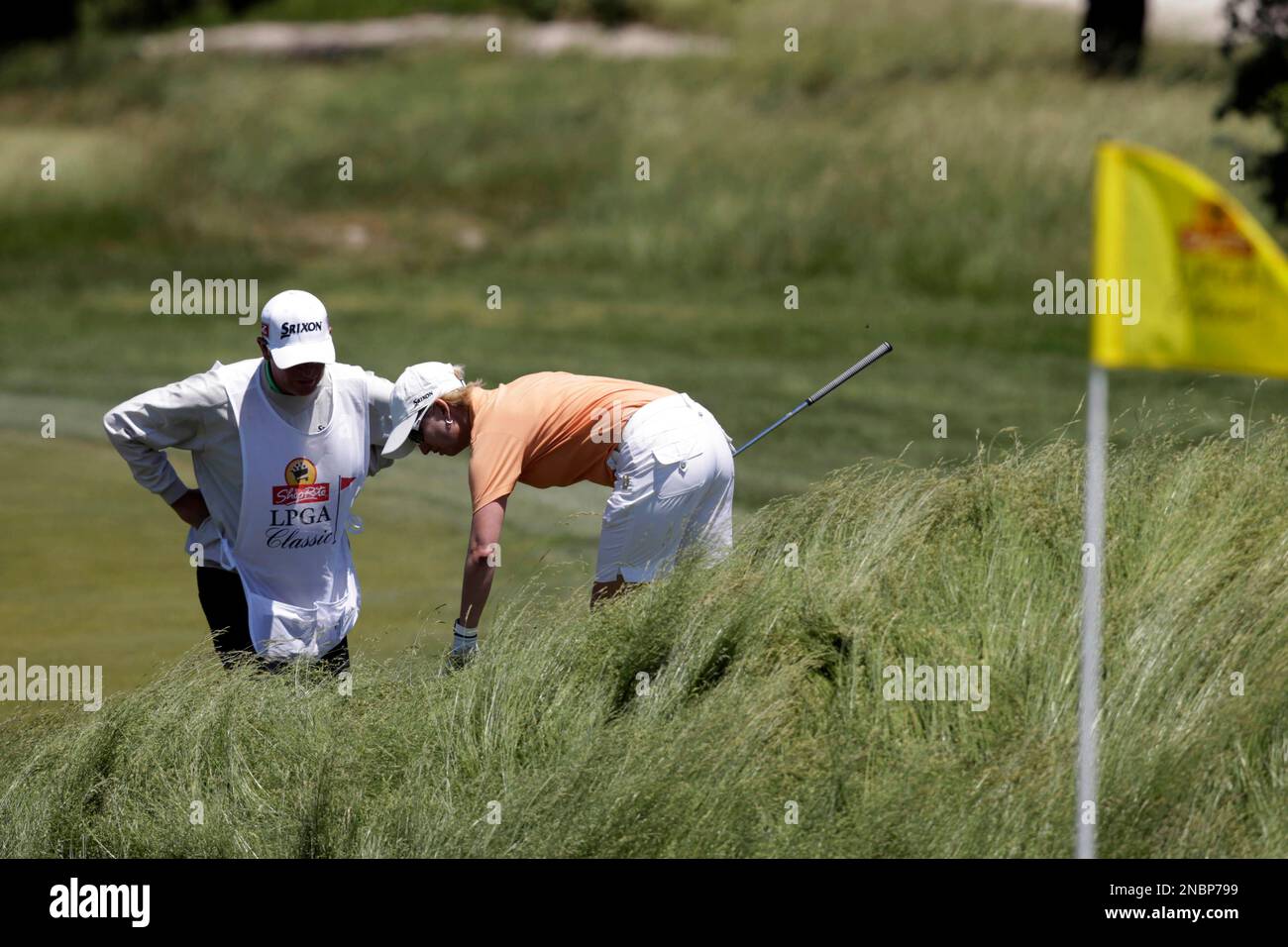 Karrie Webb, right, of Australia, looks for her ball in tall fescue on ...