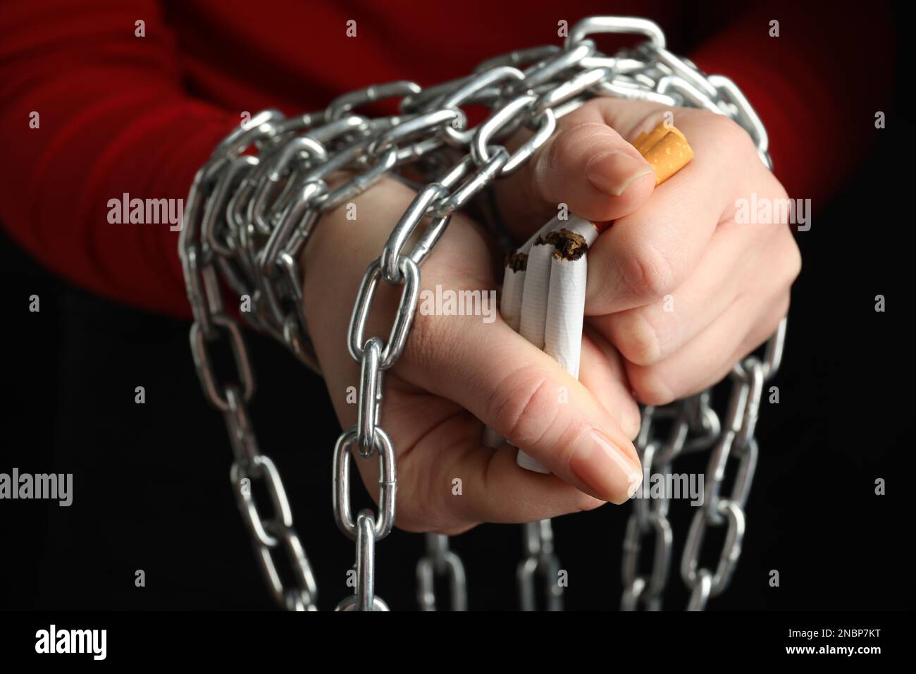 Woman with chain on hands breaking cigarettes, closeup. Quitting ...