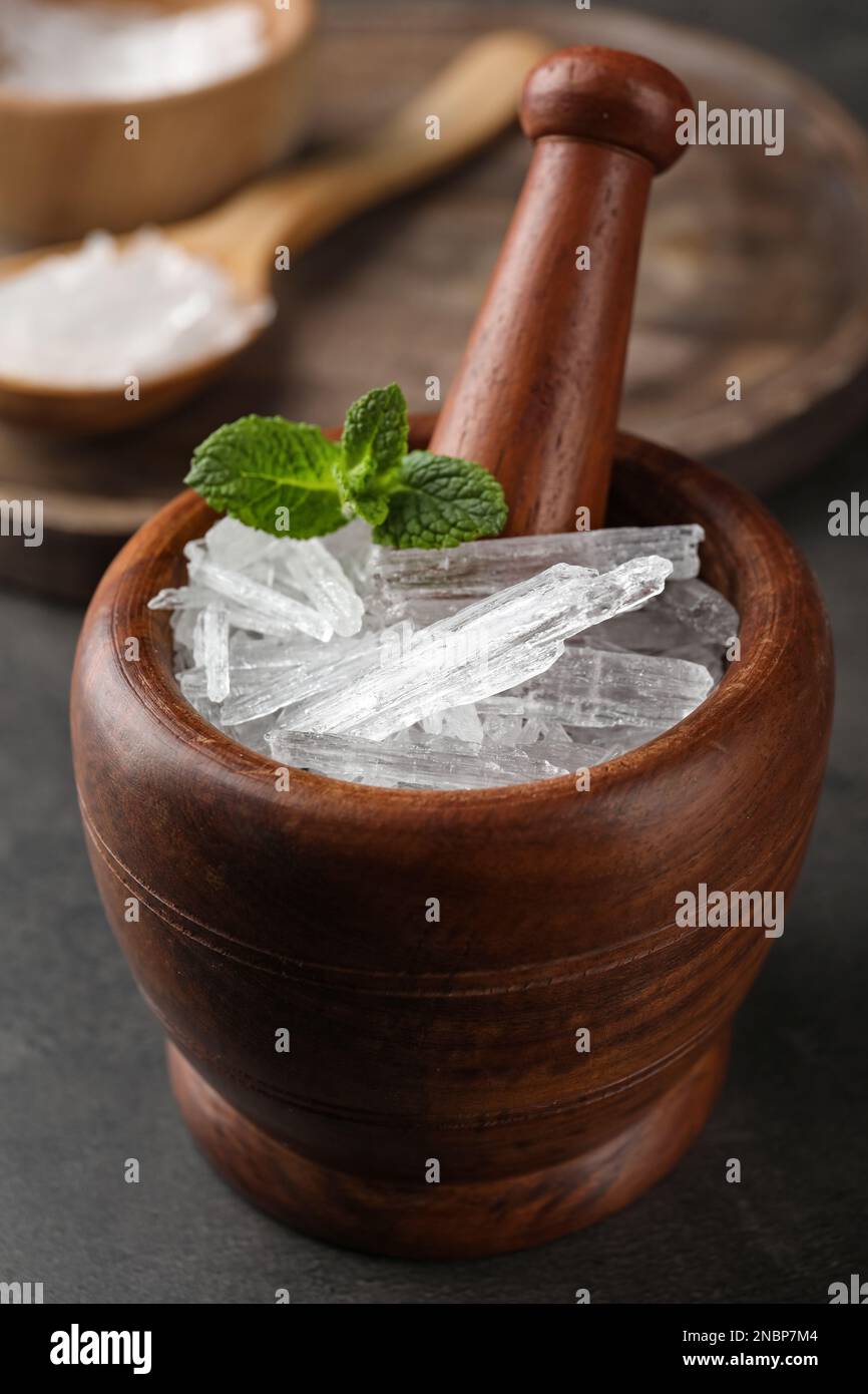 Menthol crystals and mint leaves in mortar on grey background Stock ...