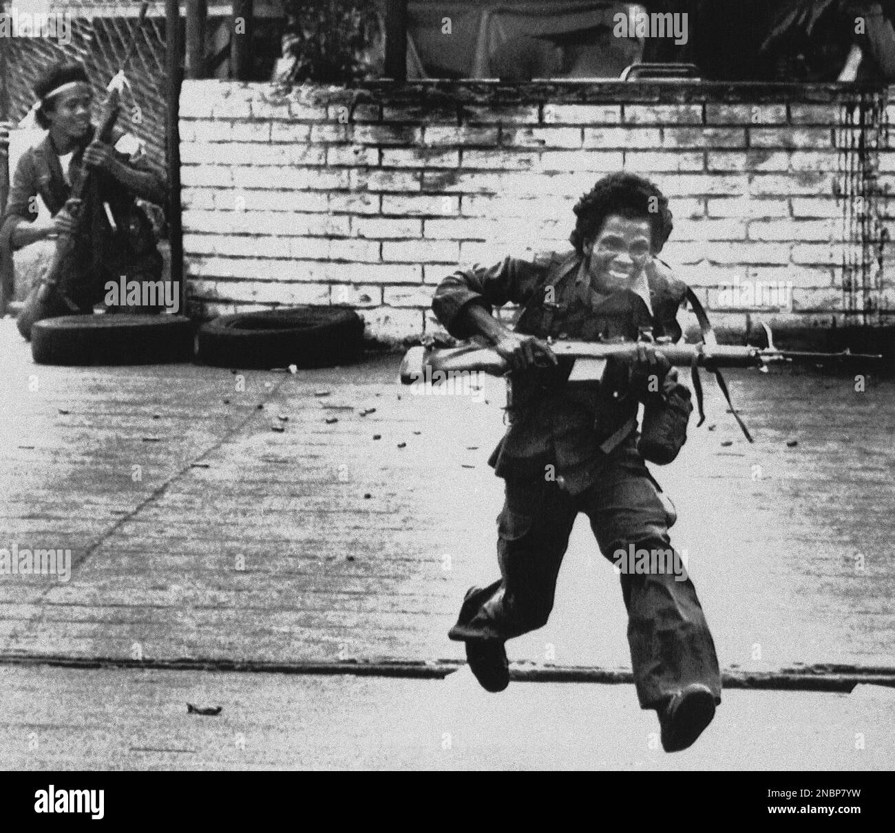 A rebel soldier is off the ground as he takes a position against sniper ...