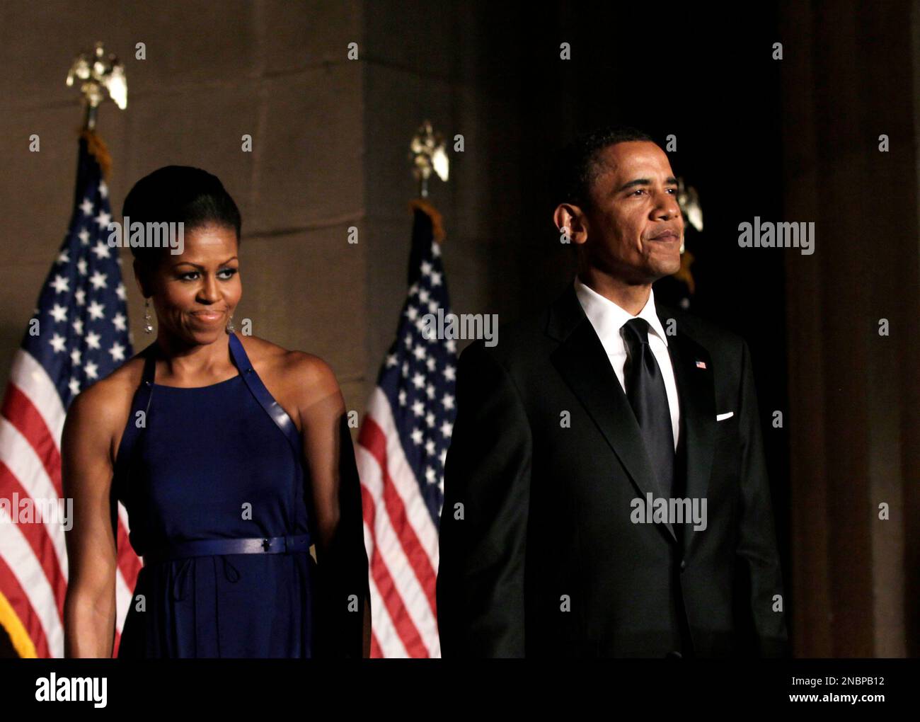 President Barack Obama and first lady Michelle Obama pause on the stage ...