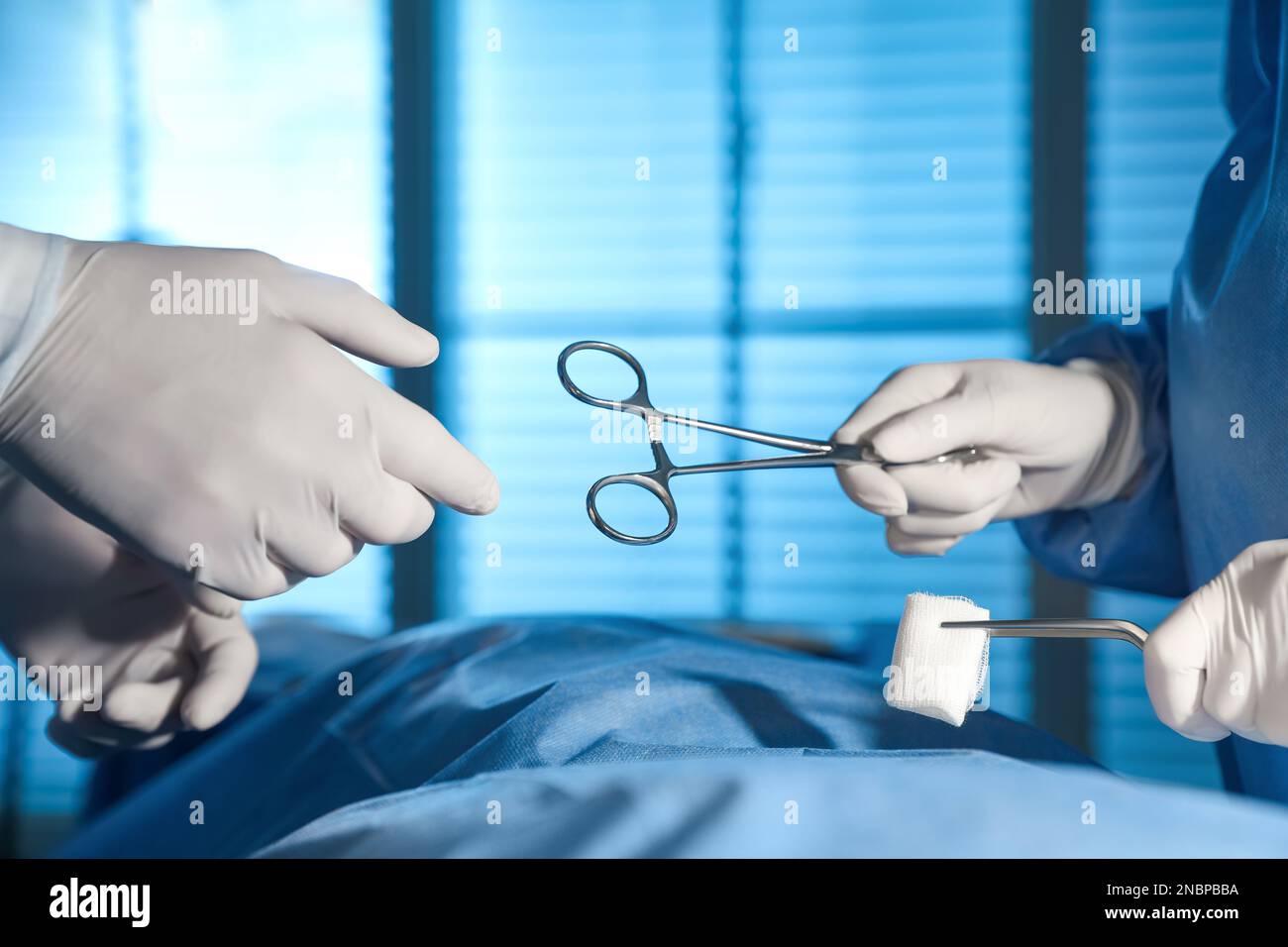 Professional surgeons with instruments performing operation in clinic ...