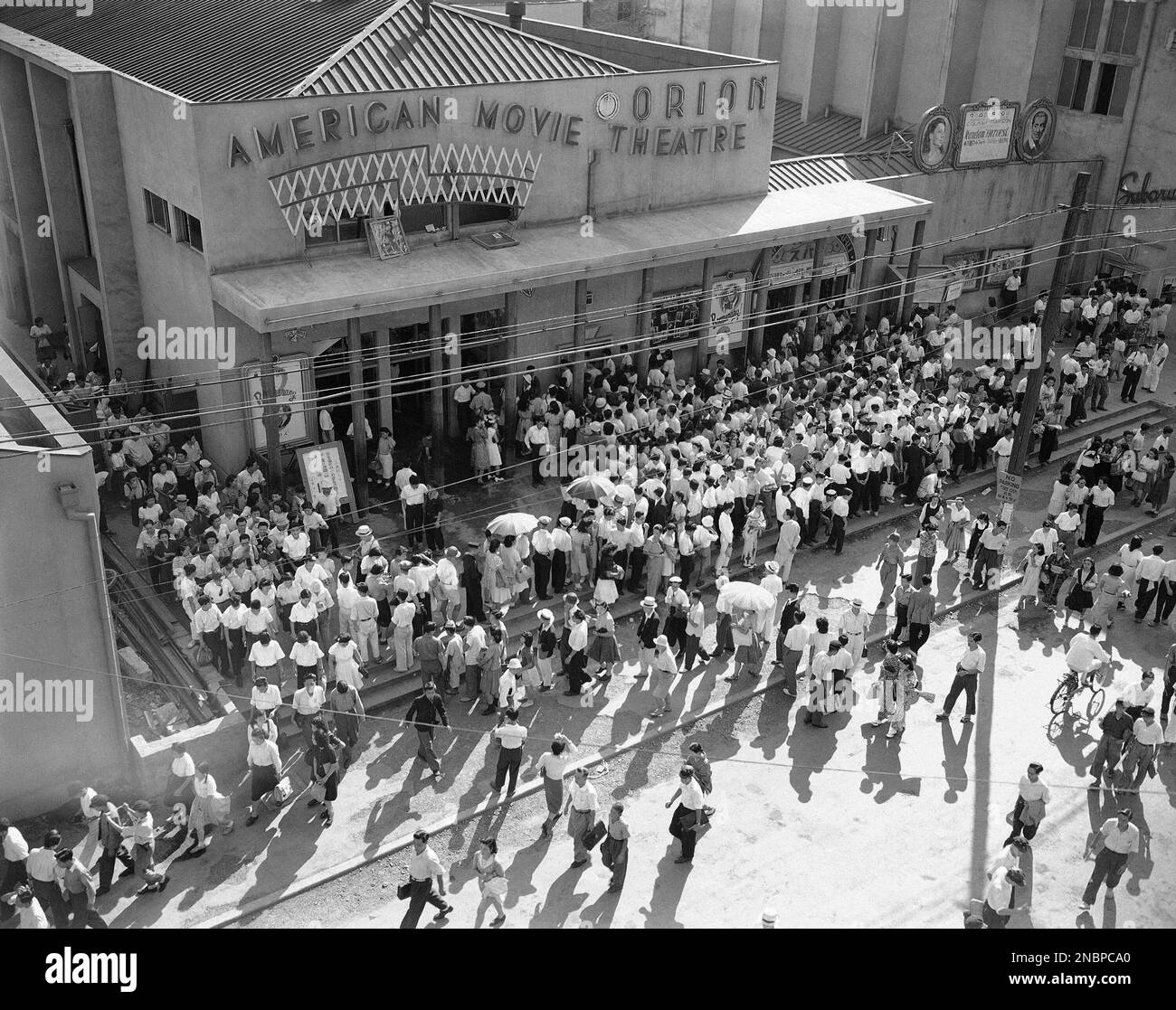 Overhead shot as Tokyo crowds gather around the American movie theatre ...