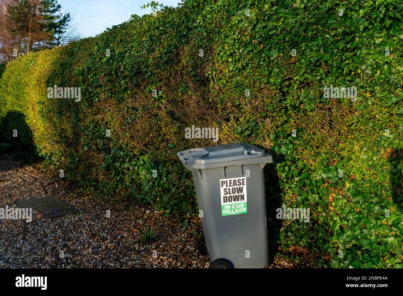 Wheelie bin with please slow down in our village sticker Stock Photo ...