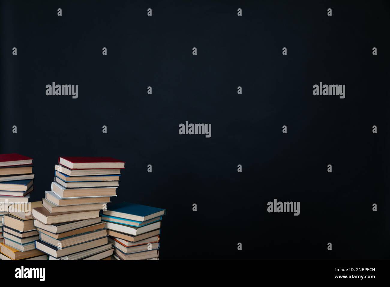 stack of books on dark background in the library at the educational ...