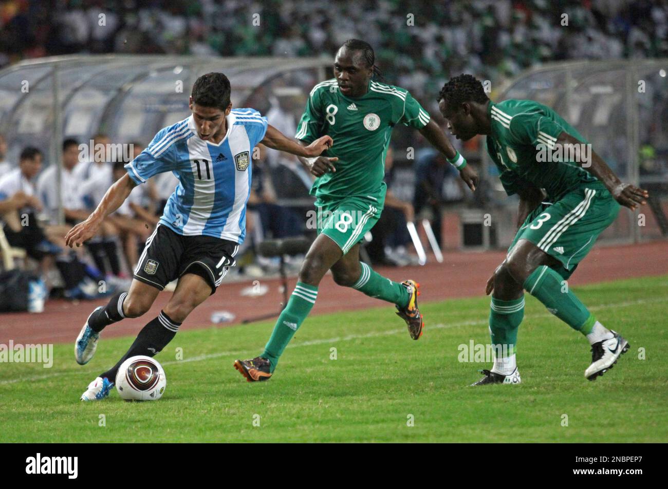 Nigeria's Taye Taiwo, right, and Peter Utaka , centre, challenge ...