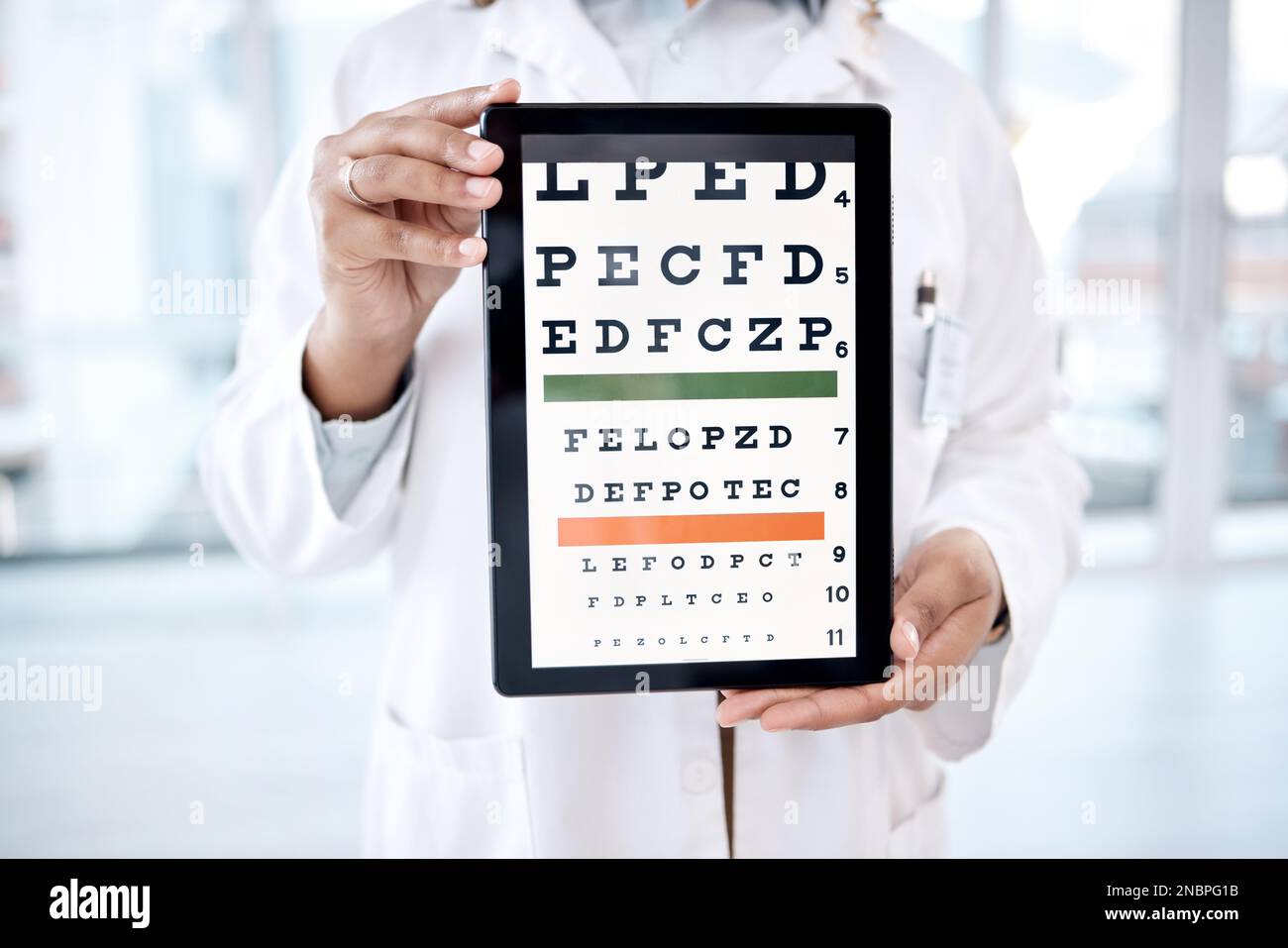 Hands, tablet screen and optometry chart in hospital for vision ...