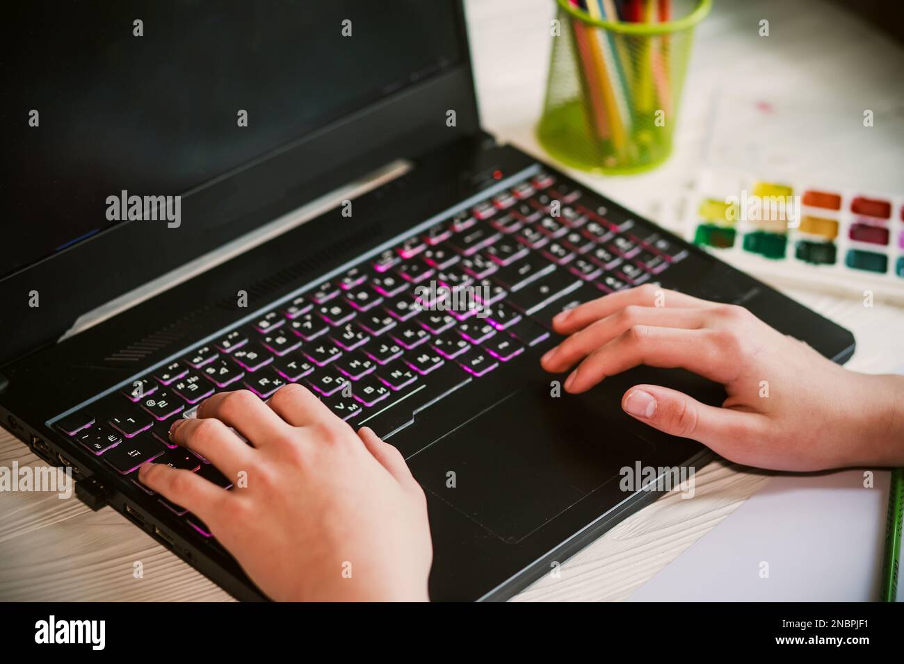 The laptop monitor screen is turned off. The child turns on the laptop ...