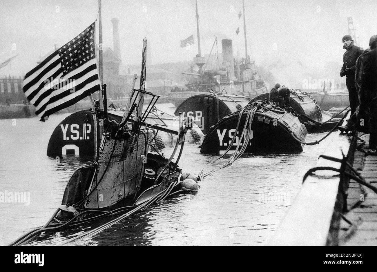 Sunken submarine, raised from the bottom by means of Camels, is brought ...