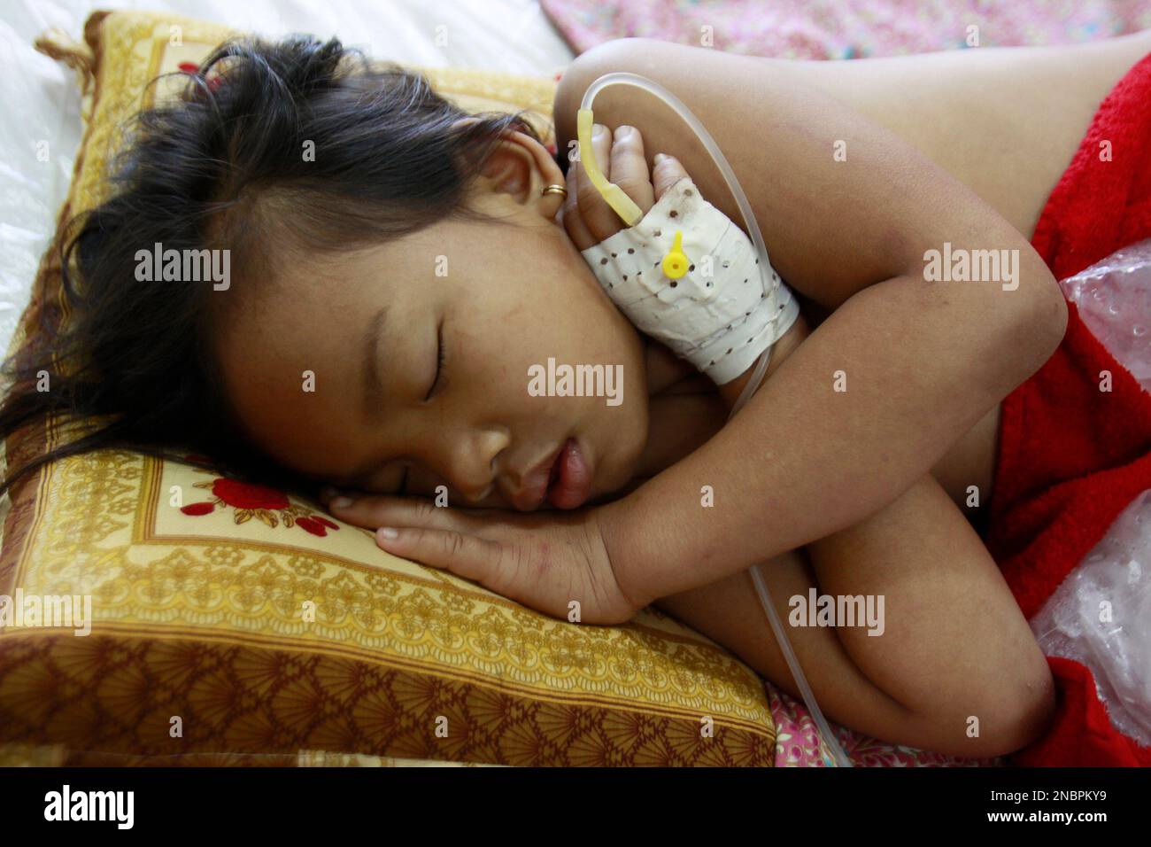Siv Gekthing, 7, who has symptoms of dengue fever sleeps in a children ...