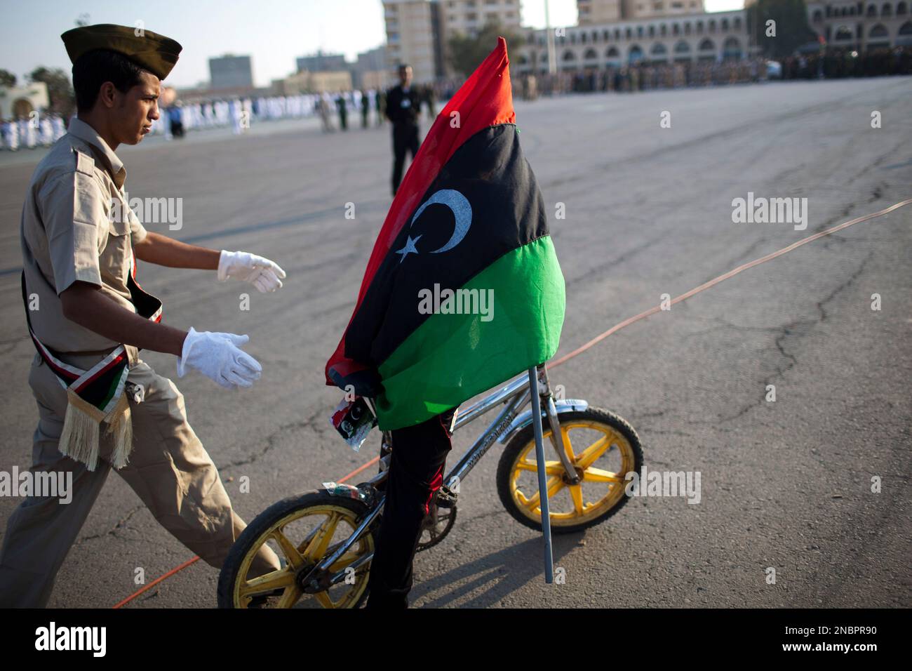 A new cadet for the rebel army tells a boy holding a pre Moammar ...