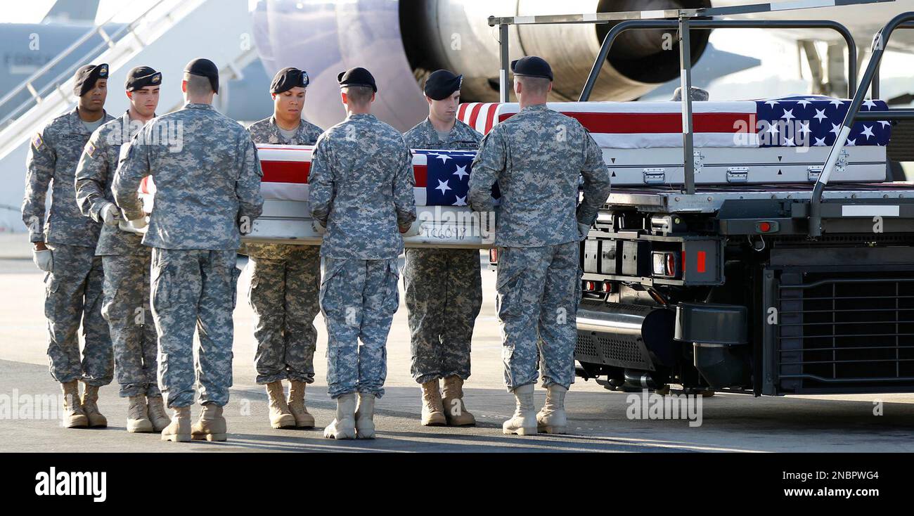 An Army carry team moves a transfer case containing the remains of 1st ...