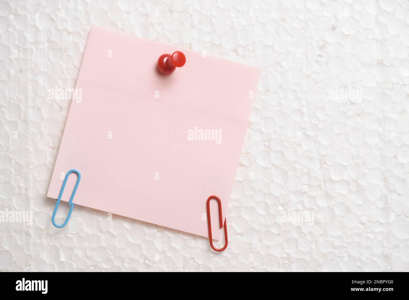 Hanging from wall with help stationery buttons is pink sticker for ...