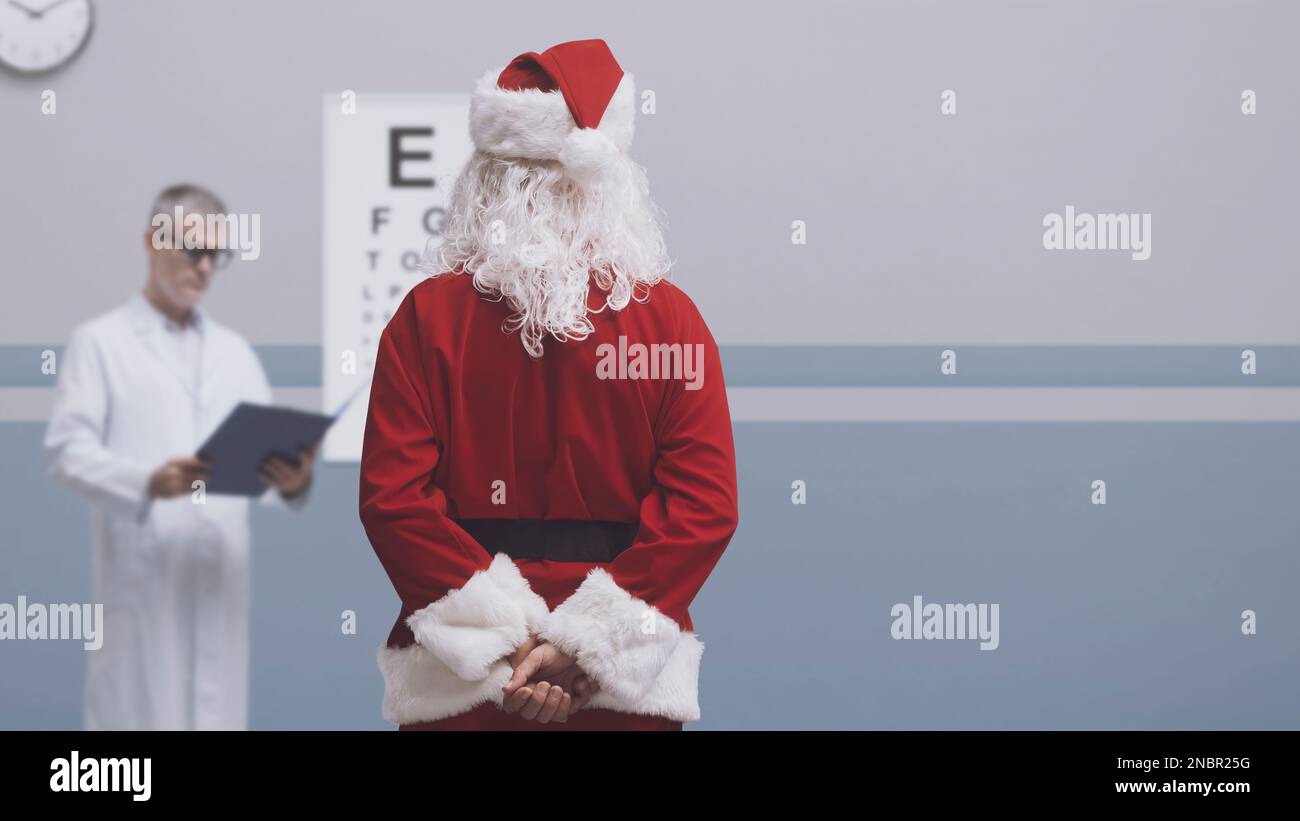 Santa Claus having an eye exam with a professional optometrist, he is ...