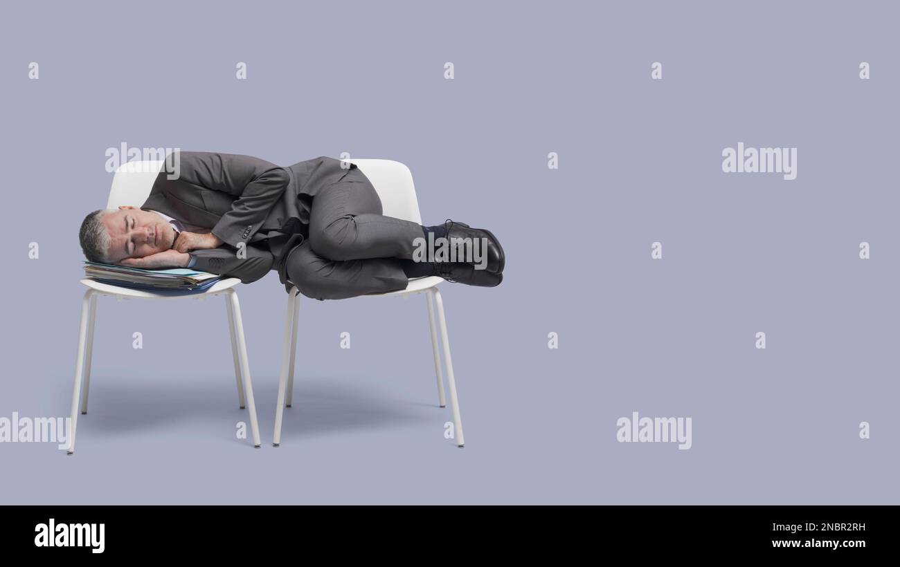 Exhausted corporate businessman lying down on chairs and sleeping Stock ...