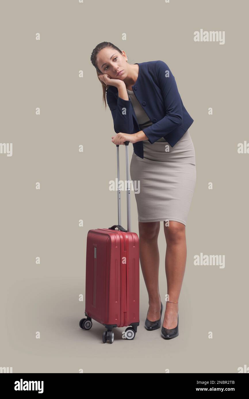 Tired disappointed businesswoman waiting at the station, she is leaning ...