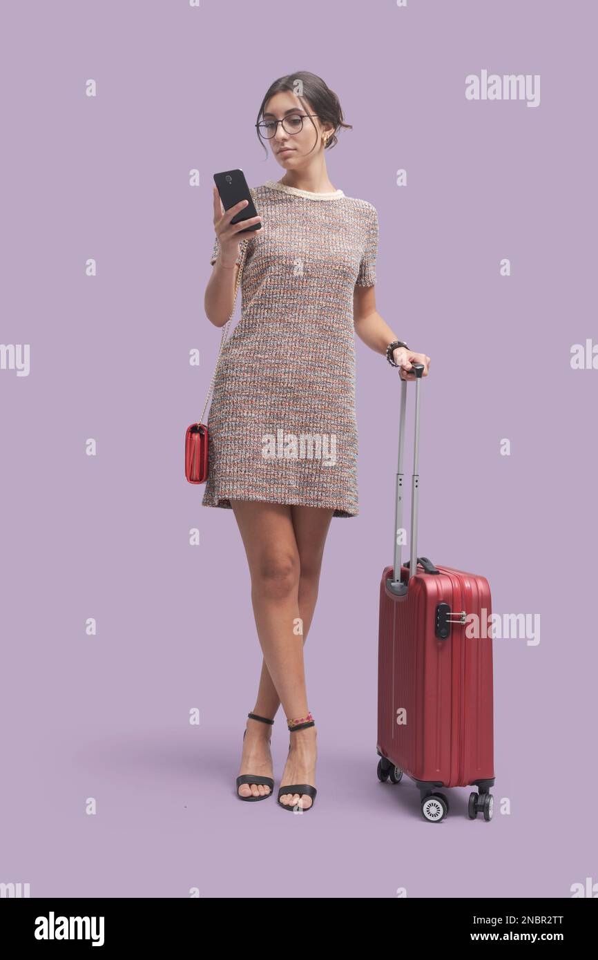 Elegant traveler woman using a smartphone, she is booking services and ...