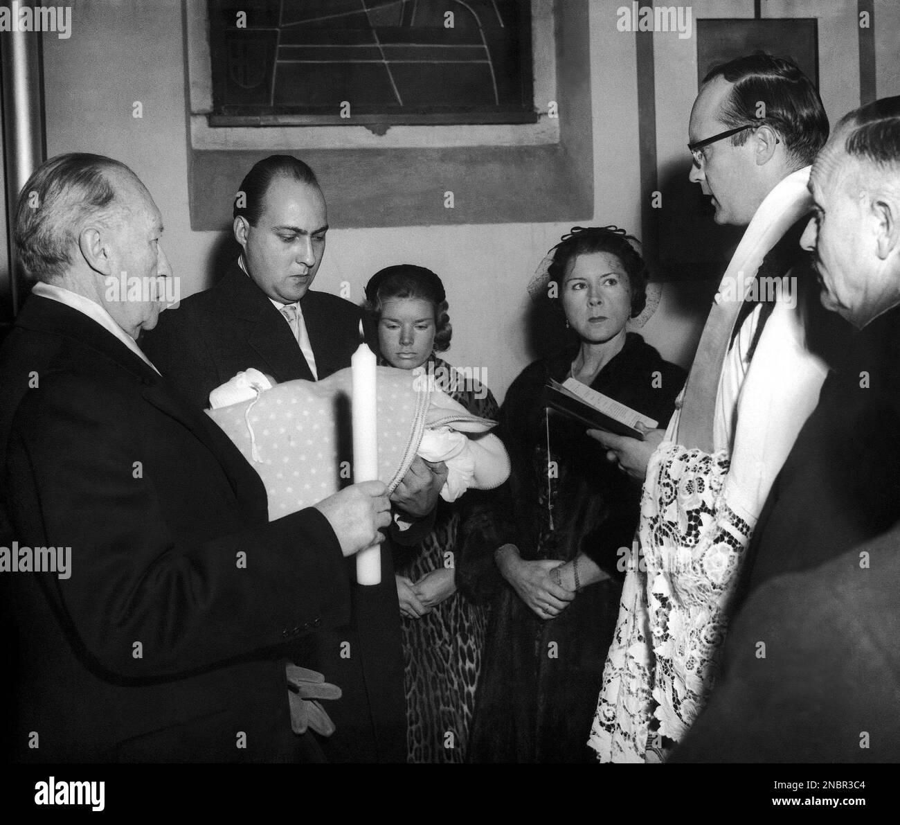 Dr. Konrad Adenauer, the West German Chancellor, left, holds a candle ...