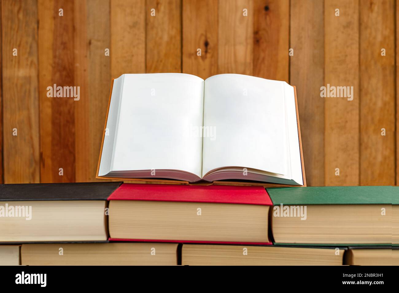 open book with blank pages on top of a stack of books placed in the ...
