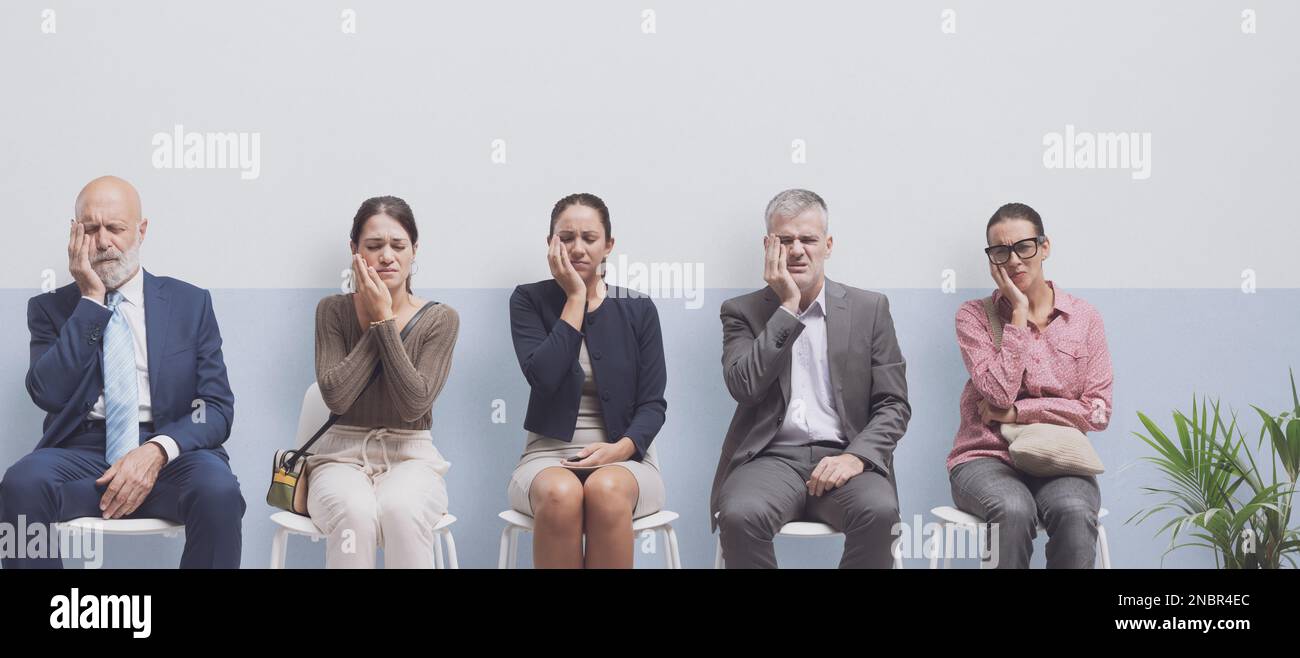 Diverse people sitting in the waiting room at the dental clinic, they ...