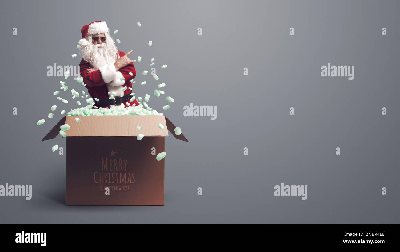 Cool trendy Santa Claus with sunglasses coming out from a delivery box ...