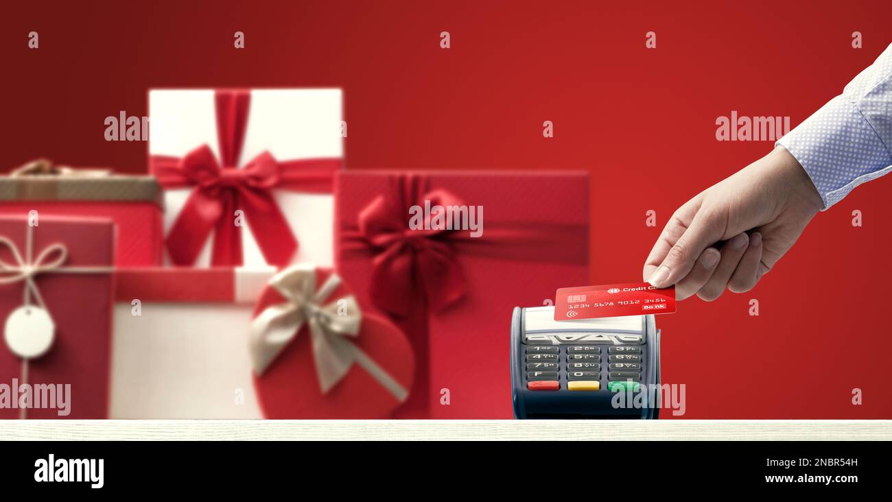 Customer buying Christmas gifts in a shop, she is holding the credit ...
