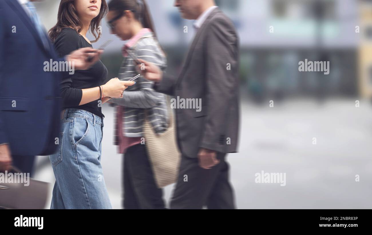 Crowd of distracted people walking in the city street and using ...