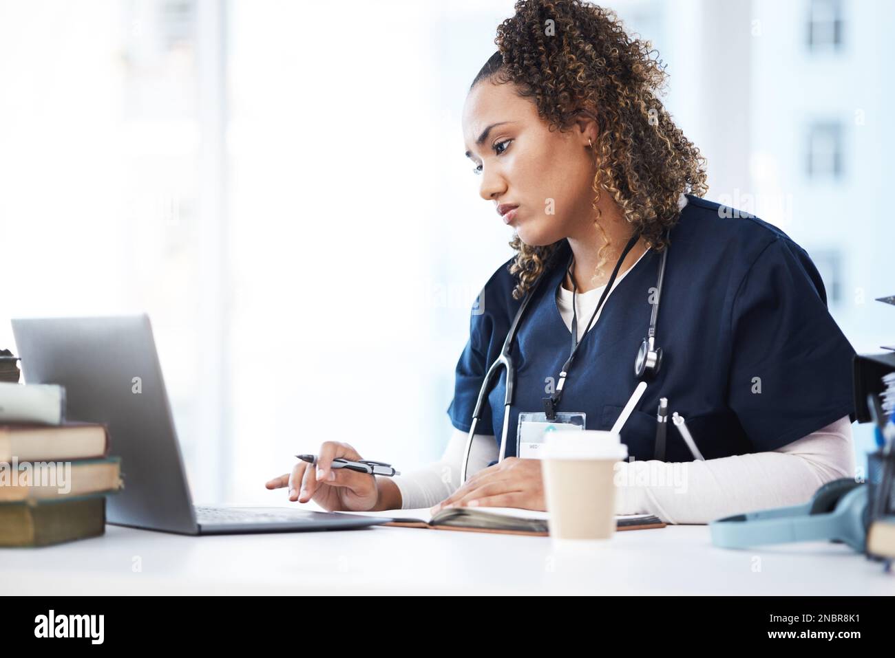 Medical, laptop and research with a woman nurse reading information in ...
