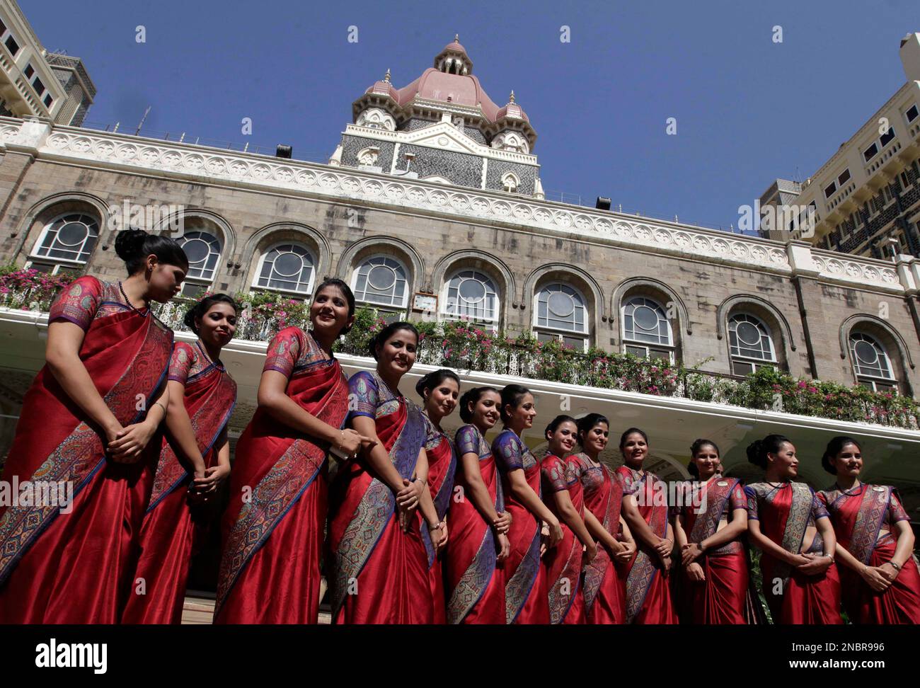 The staff of the Taj Mahal Palace Hotel pose for the media wearing ...