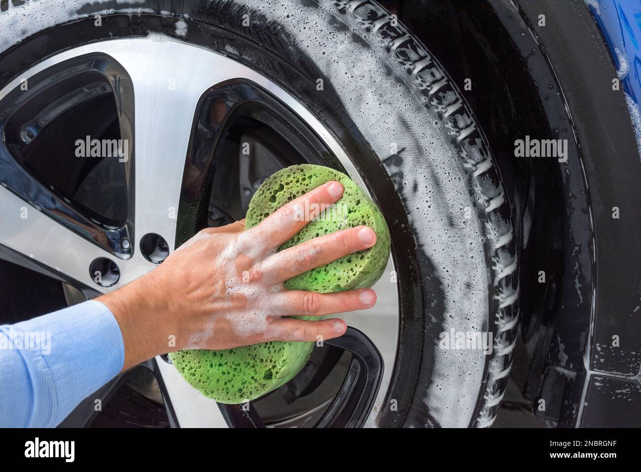 Foam and soap on the car wheel. Washing a car Stock Photo - Alamy