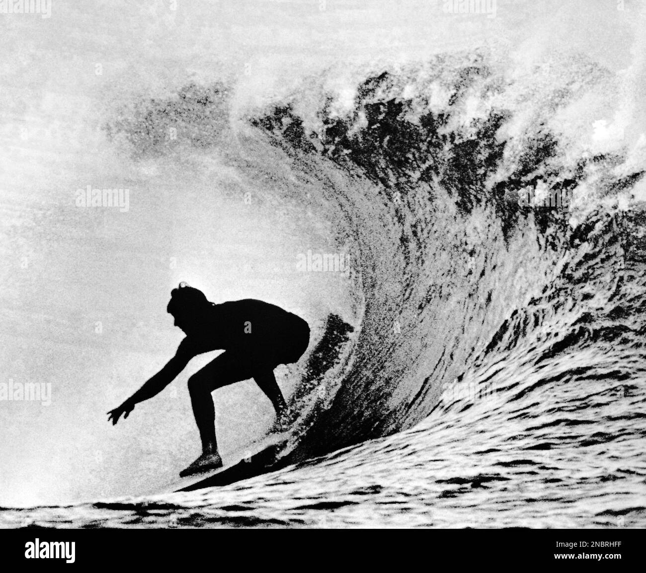 A surfer in the shadow of a huge wave off the Island of Oahu, Hawaii on ...
