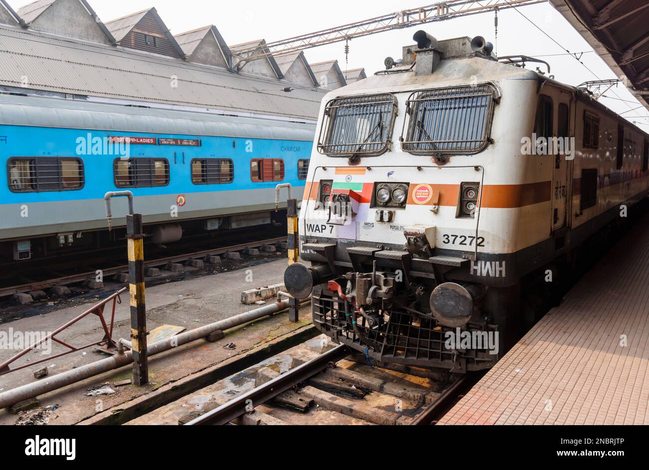 White Indian Railways train locomotive engine standing at a platform at ...