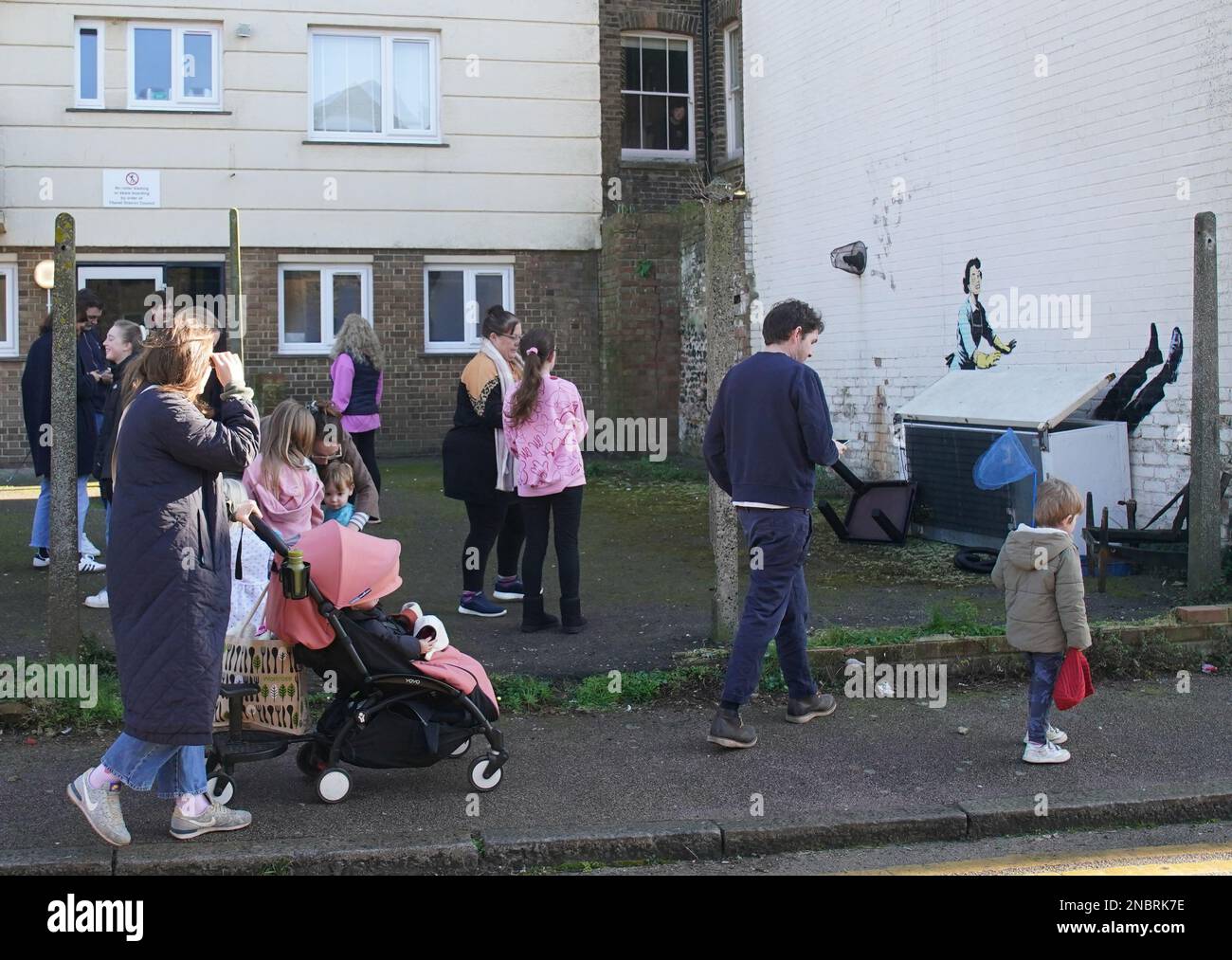 Members of the public gather to view a new artwork by street artist ...
