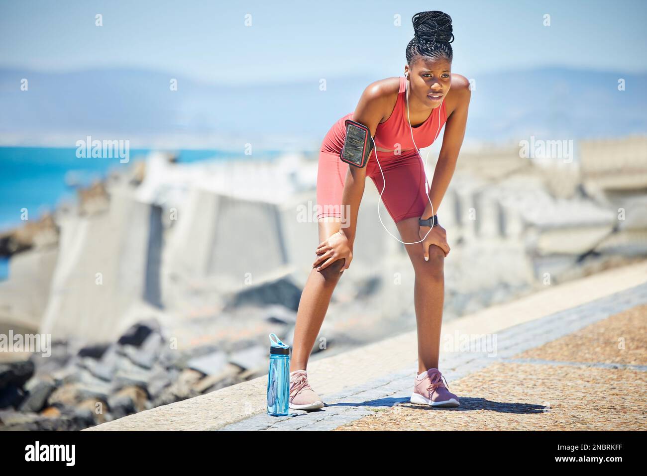 Tired runner, black woman and running with fatigue by the ocean for ...