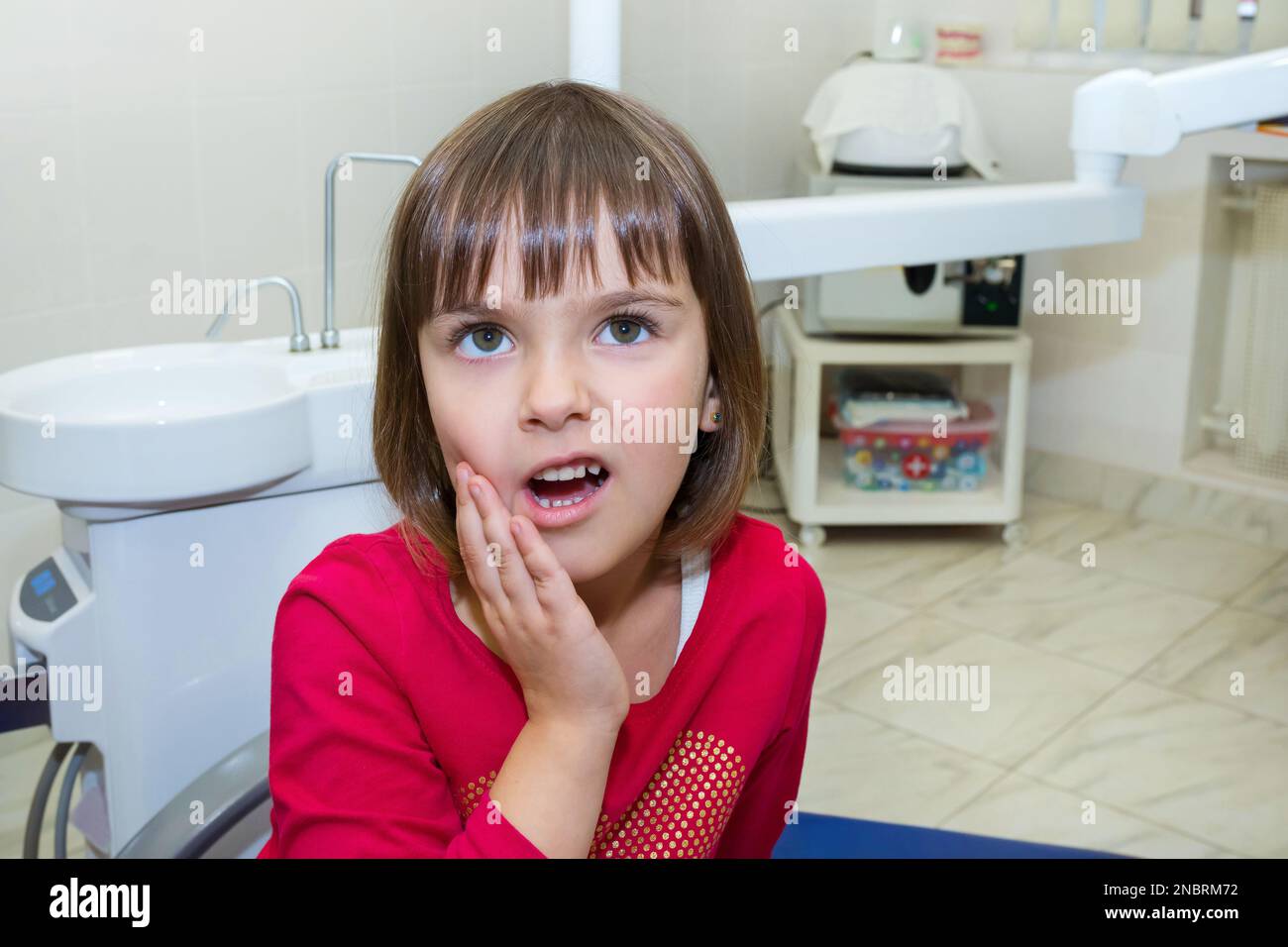 A little kid with a toothache at a dentists office Stock Photo - Alamy