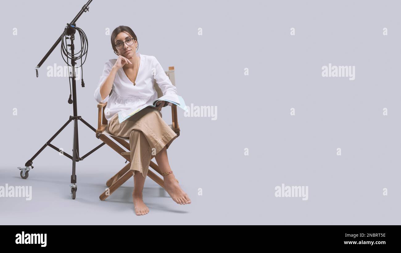 Confident professional actress sitting on the director's chair and ...