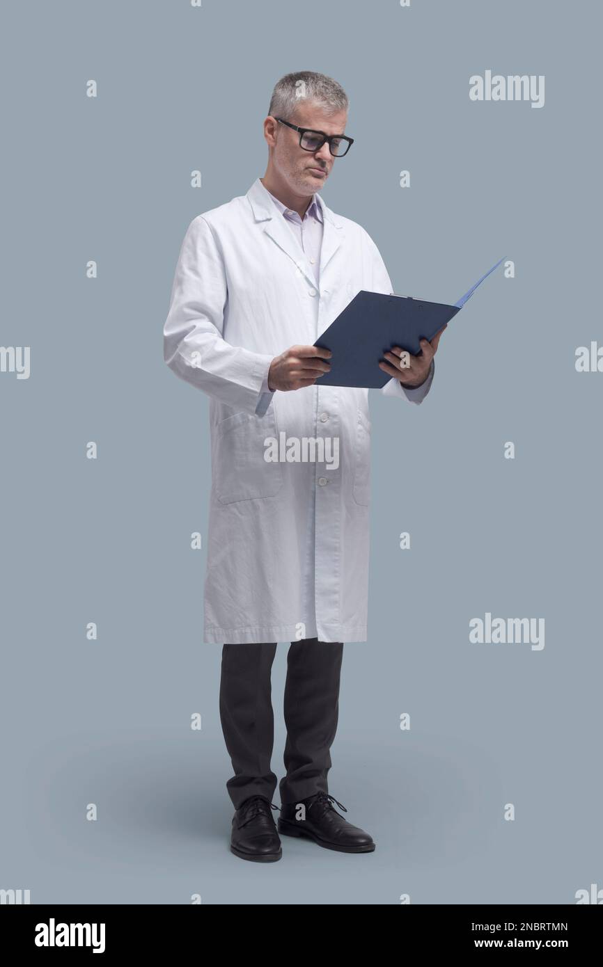 Professional doctor standing and checking medical records, healthcare ...