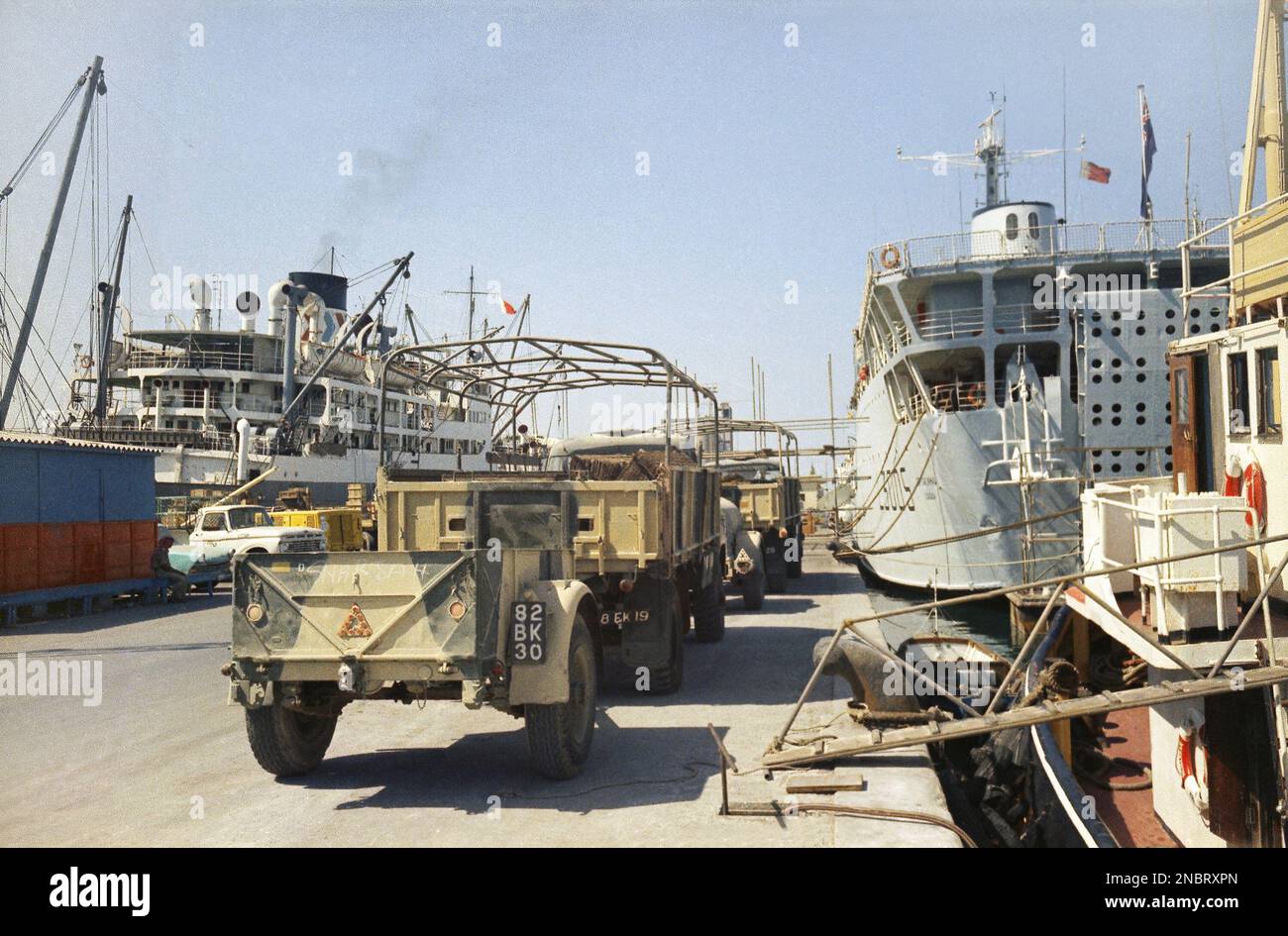 British Army vehicles wait to be loaded on a commercial freighter ...