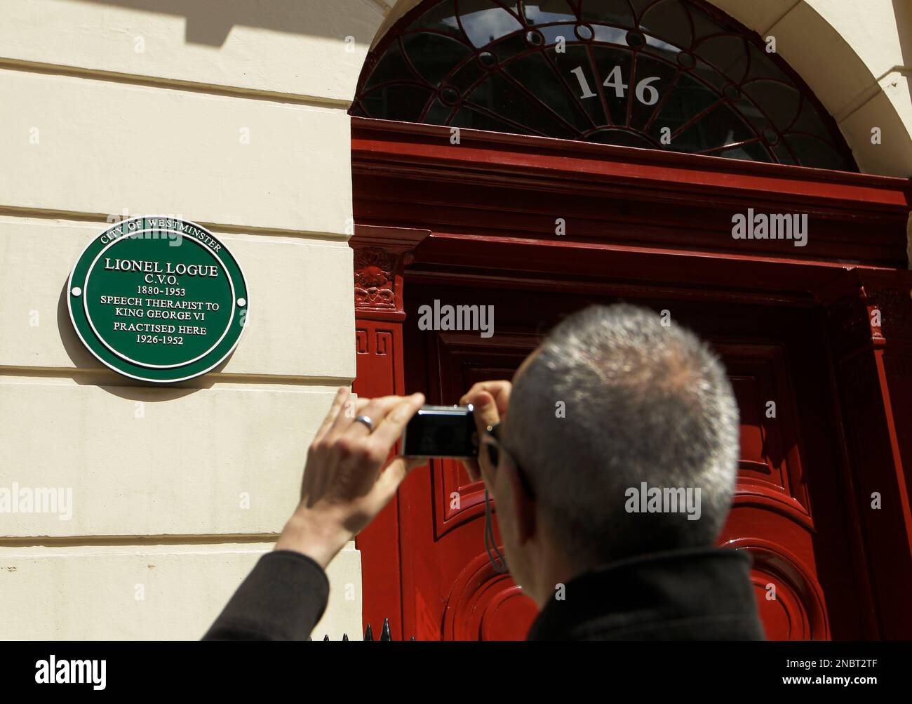 A man takes picture of a Green Plaque unveiled to commemorate Lionel ...