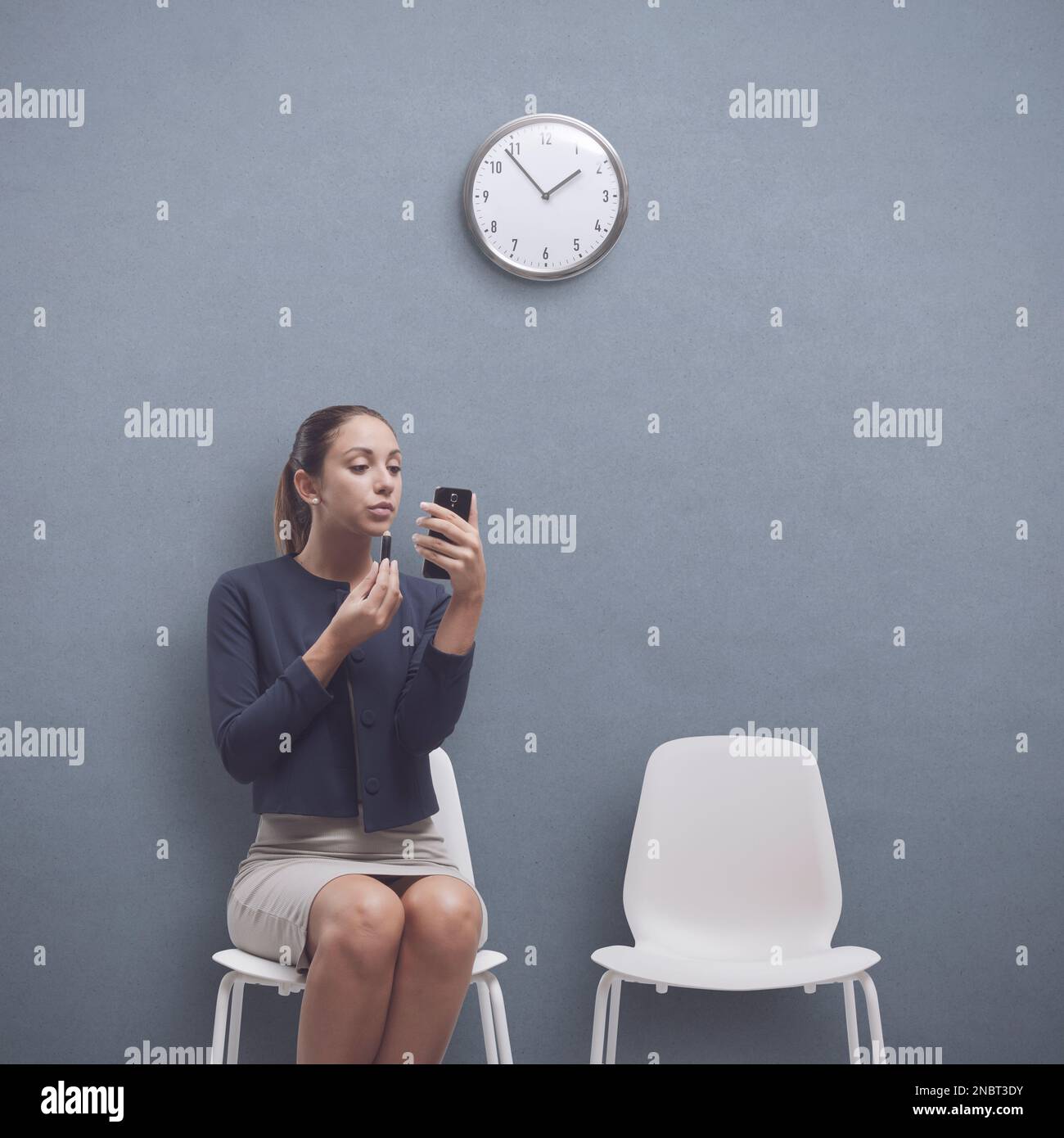 Attractive woman touching up her makeup before having a job interview ...