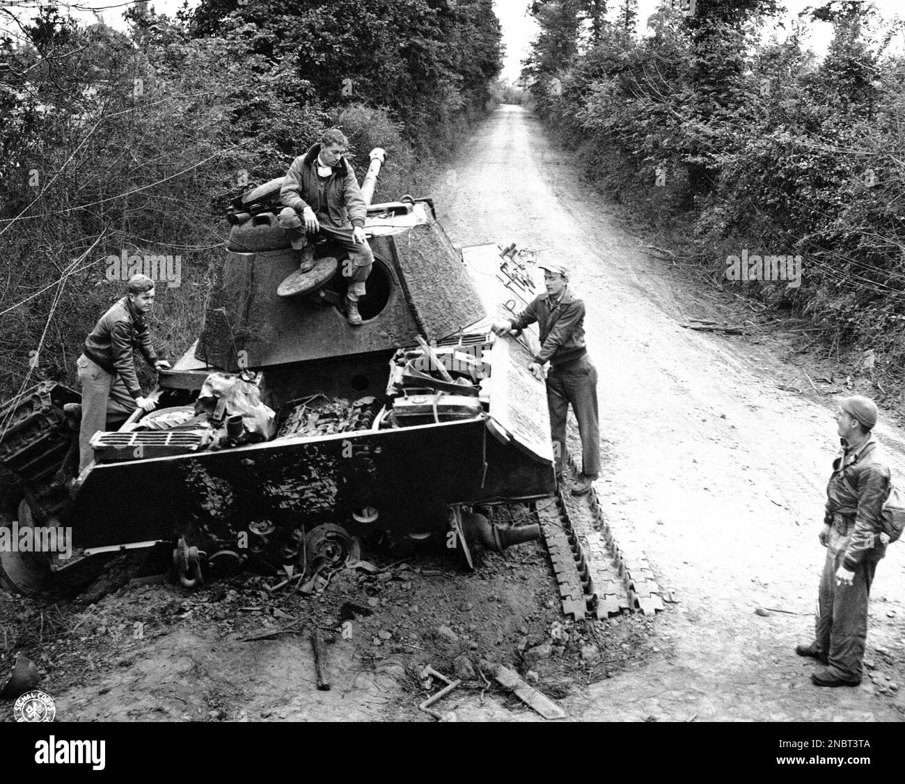 This tank, knocked out by American tankers, is examined by members of ...