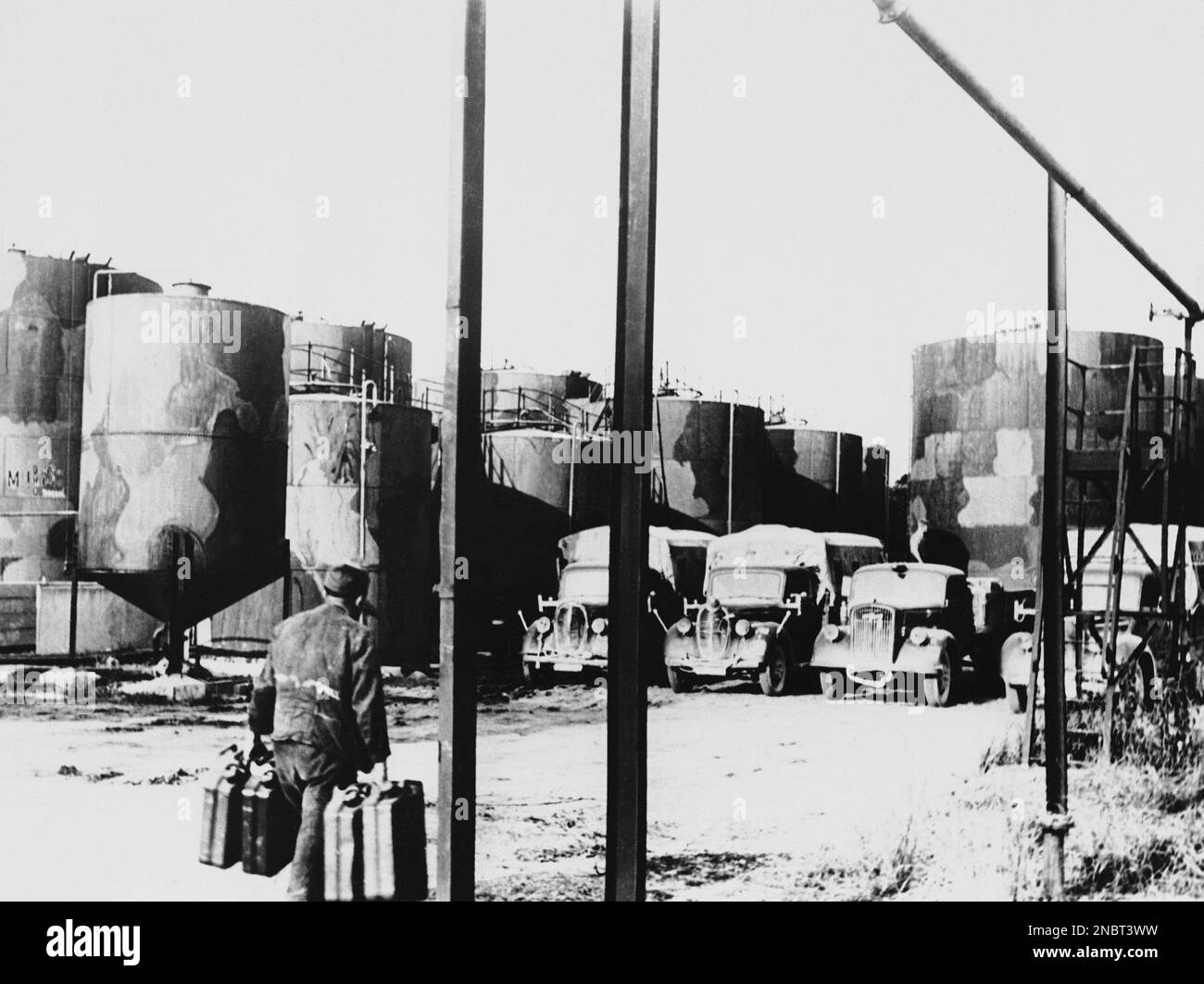 A German mechanic carries drums toward French oil tanks in France on ...