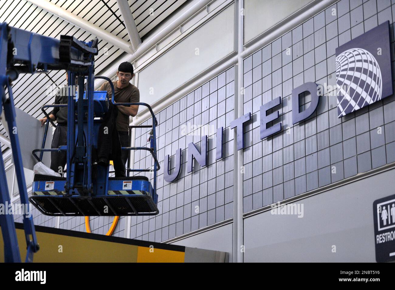 Workers unveil the new United Airlines logo at its ticket counters at O ...