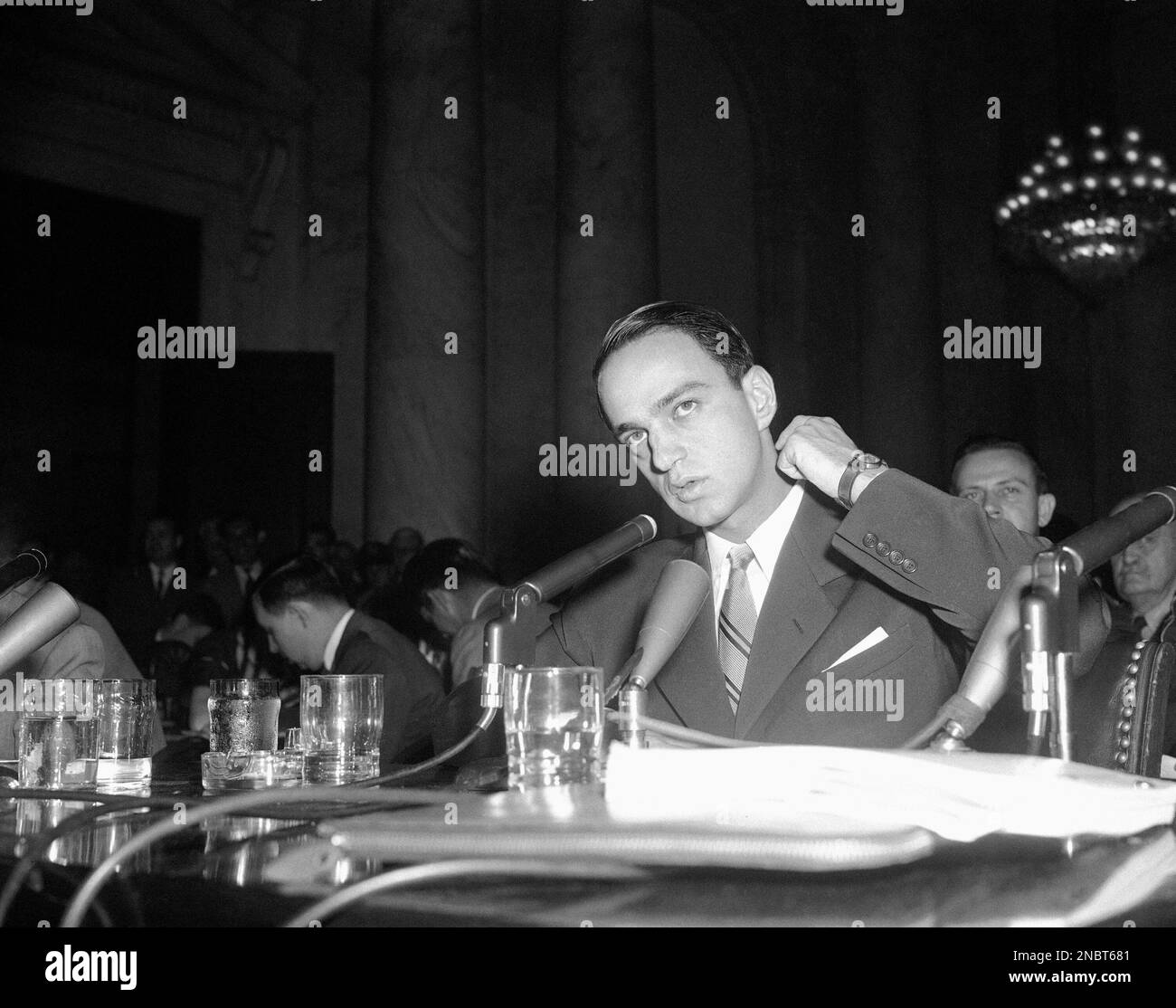 Roy Cohn scratches his neck as he appears on the witness stand to tell ...