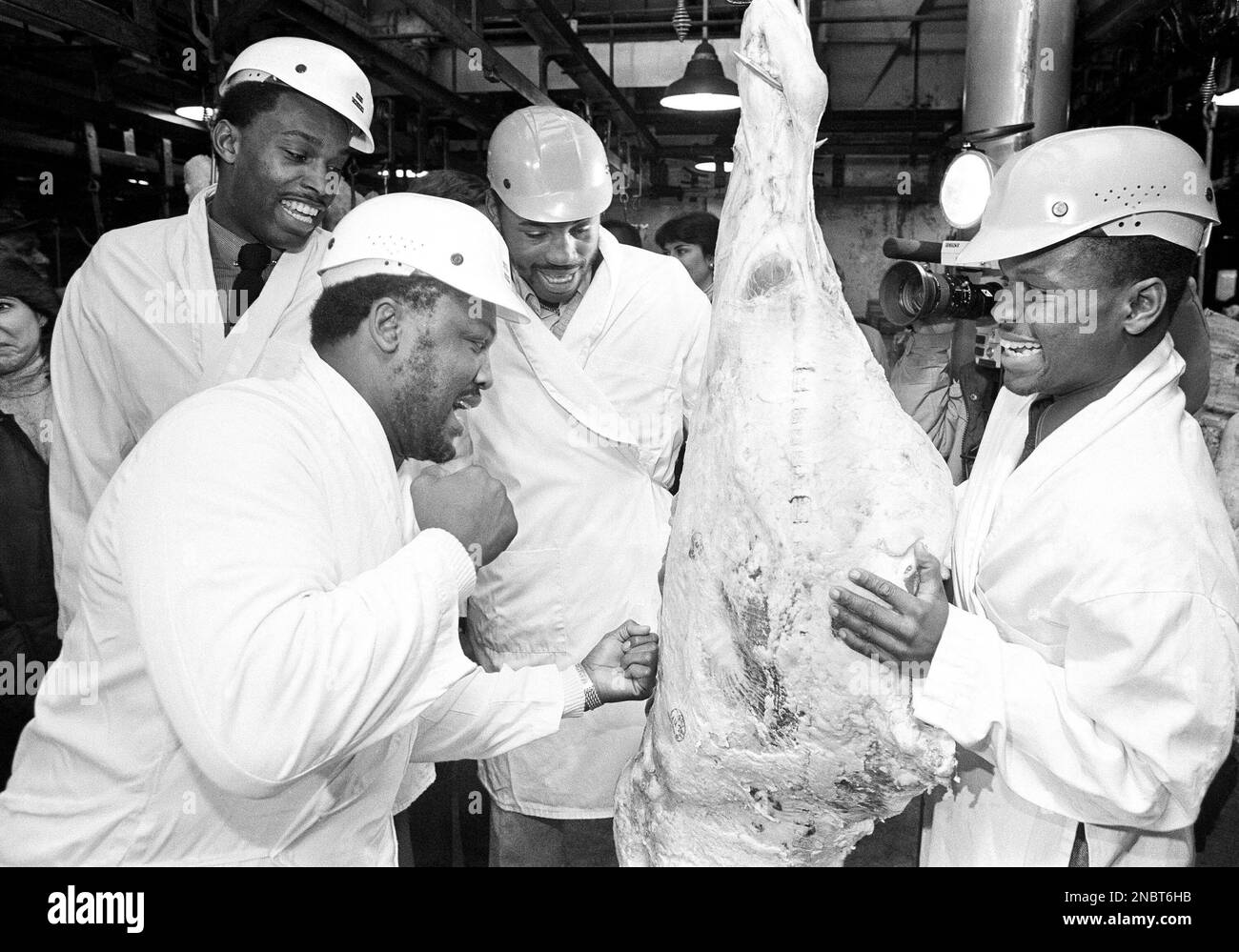 Former heavyweight champion Joe Frazier pounds away at a side of beef ...
