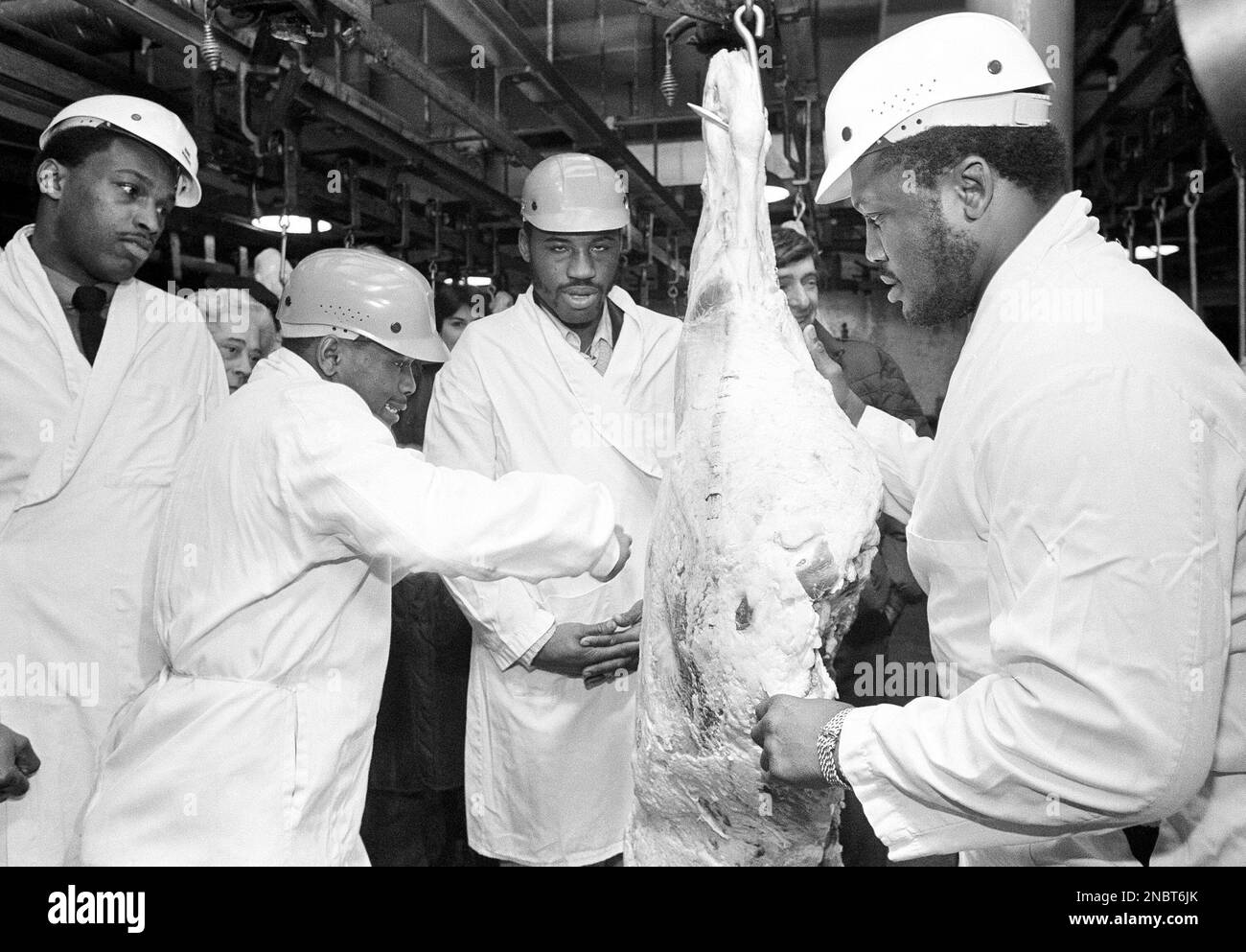 Former heavyweight champion Joe Frazier pounds away at a side of beef ...