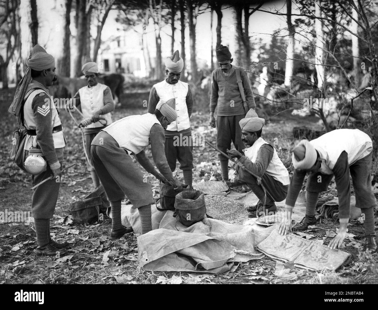 While an officer, left, watches, these members of the Royal Indian Army ...